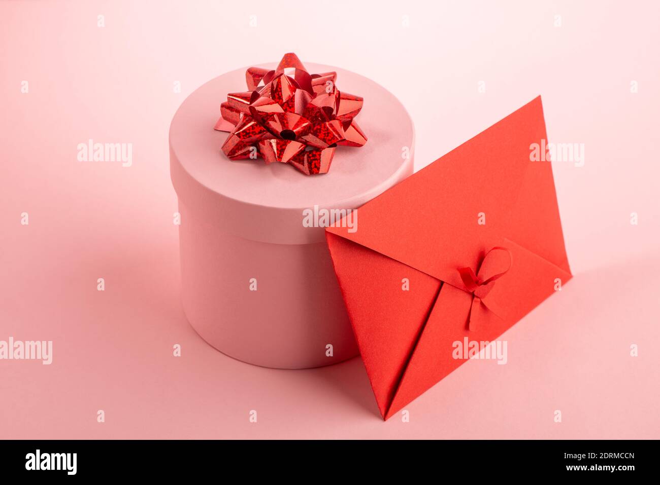 Pink round gift box and red envelope on pink background Stock Photo - Alamy