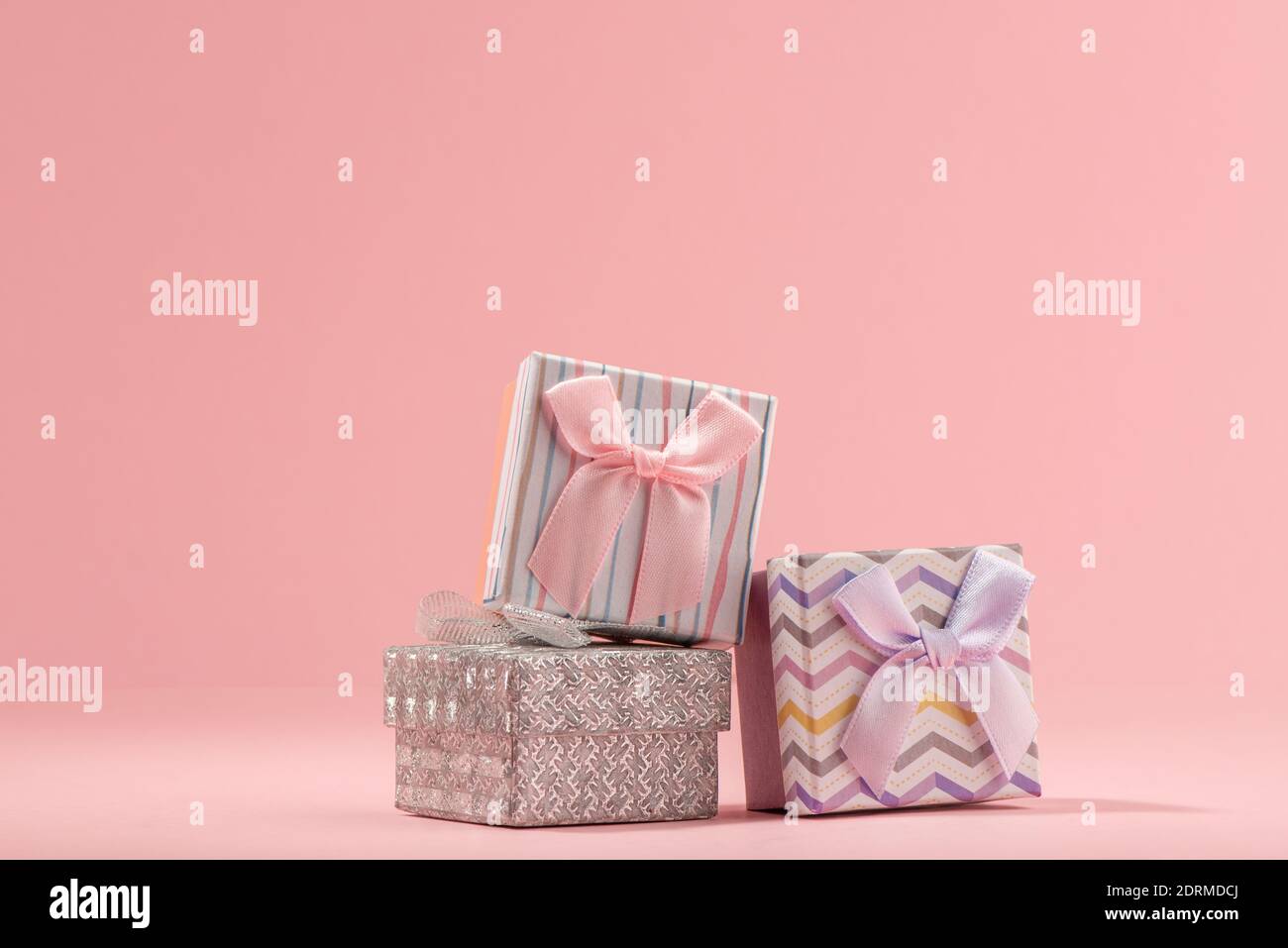 Pile of little gift boxes on pink background Stock Photo - Alamy