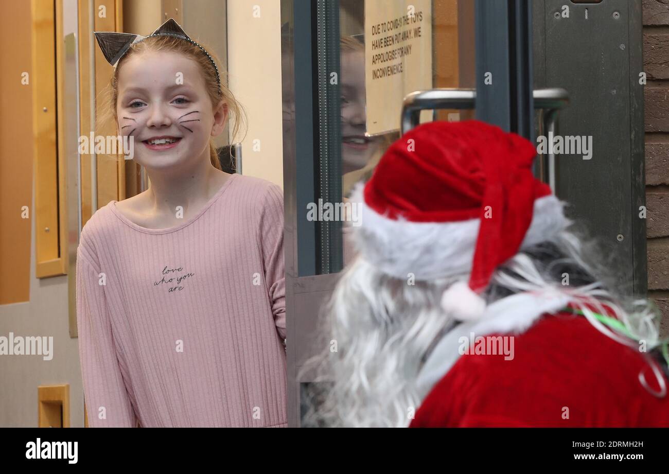 A man dressed as Santa Claus speaks to Darcie Jones, aged 8, as he ...