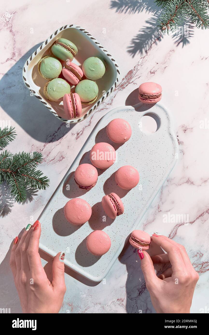 Pink and mint green macaroons on a tray and in ceramic bowl. Female ...