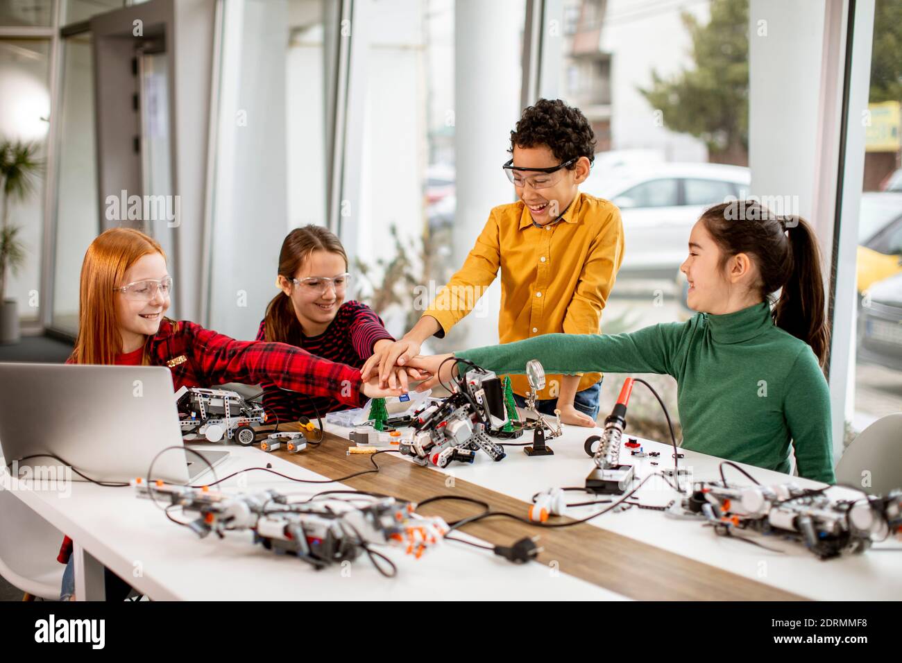 Group of happy kids programming electric toys and robots at robotics ...