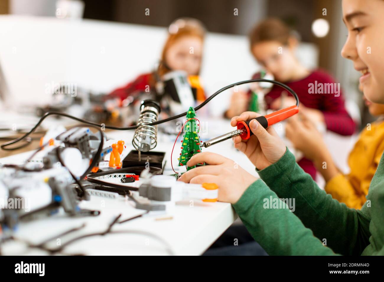 Group of happy kids programming electric toys and robots at robotics ...