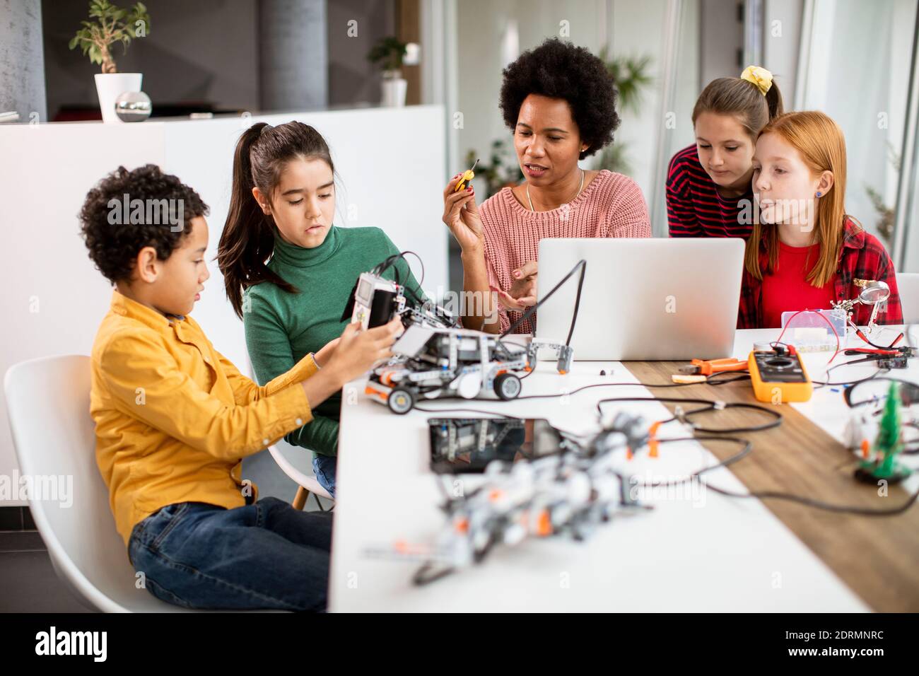 Group of happy kids with their African American female science teacher ...