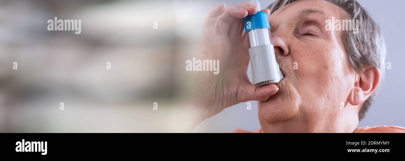 Senior woman using an asthma inhaler; panoramic banner Stock Photo - Alamy