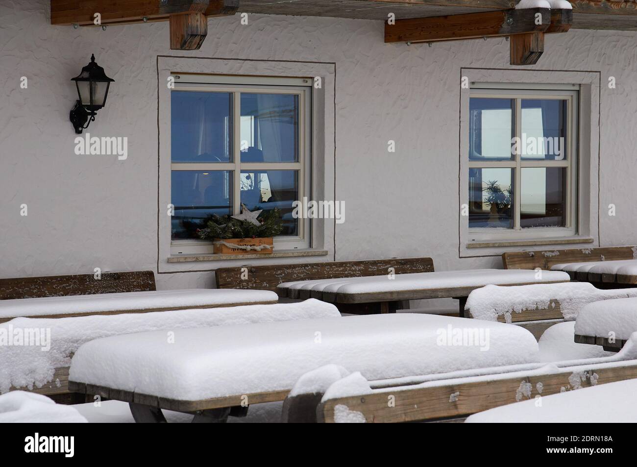 Christmas decoration in the window of a ski hut, in front of it wooden ...