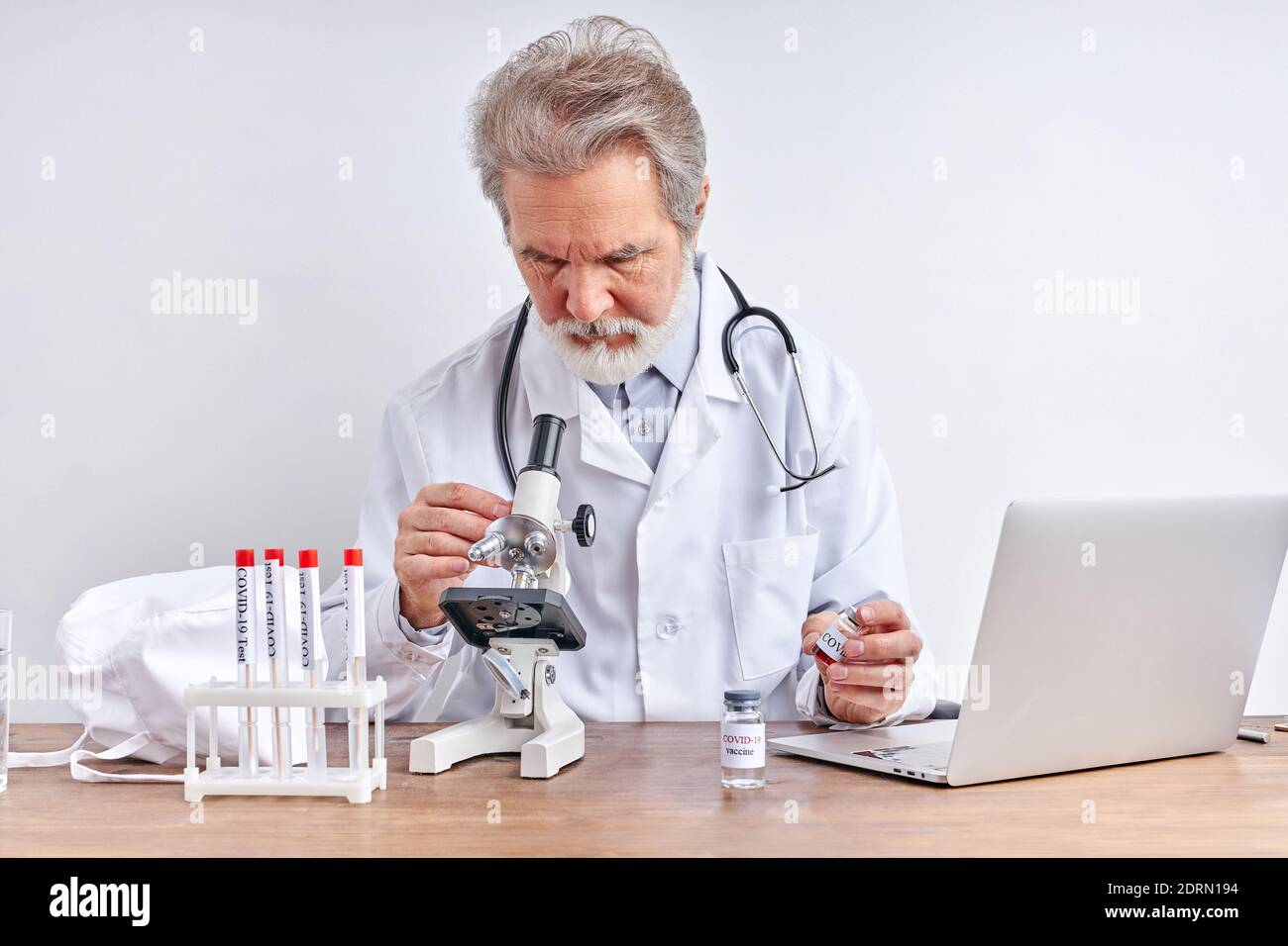 doctor examining, studying the coronavirus tests in tube in the office ...