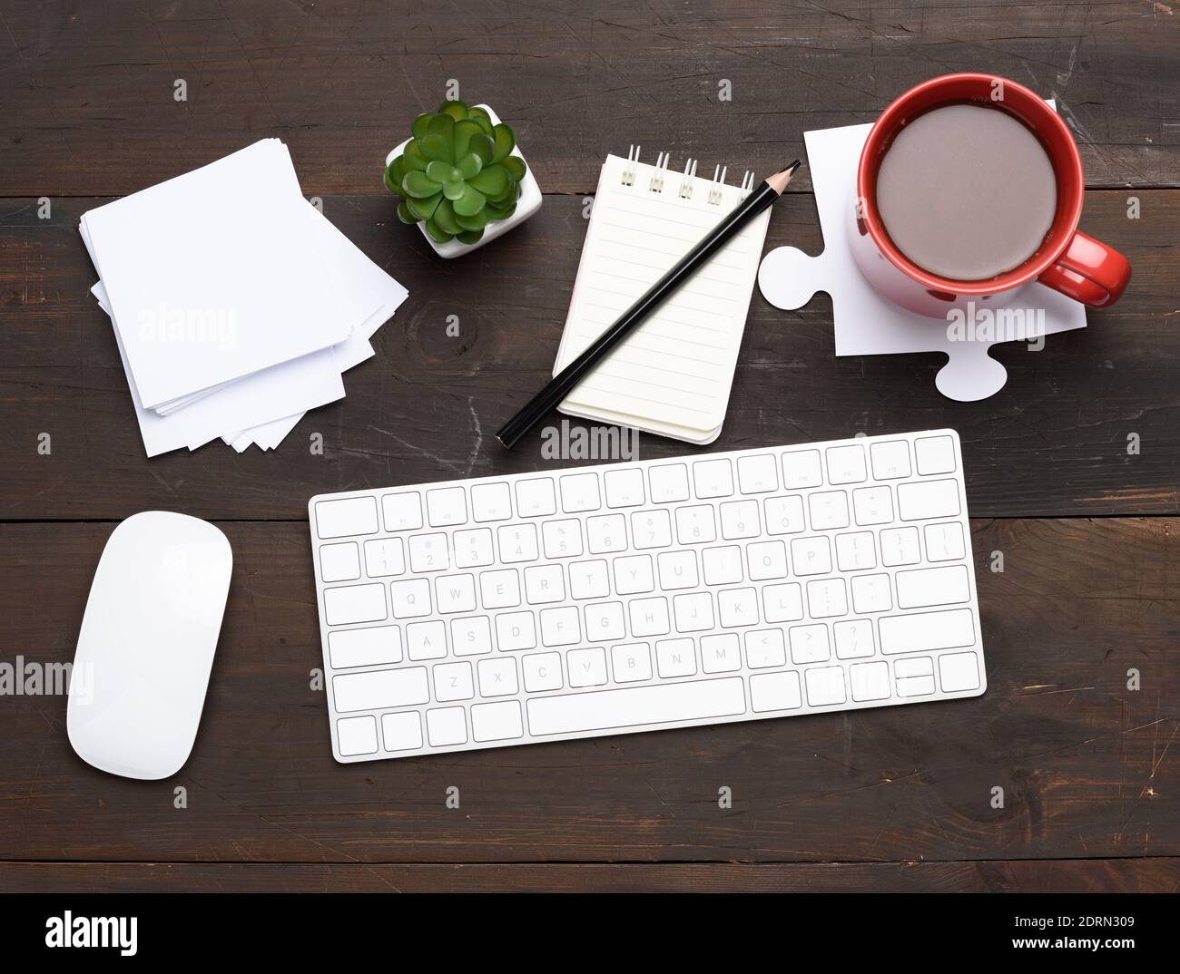 white wireless keyboard and mouse on a wooden brown table, top view ...