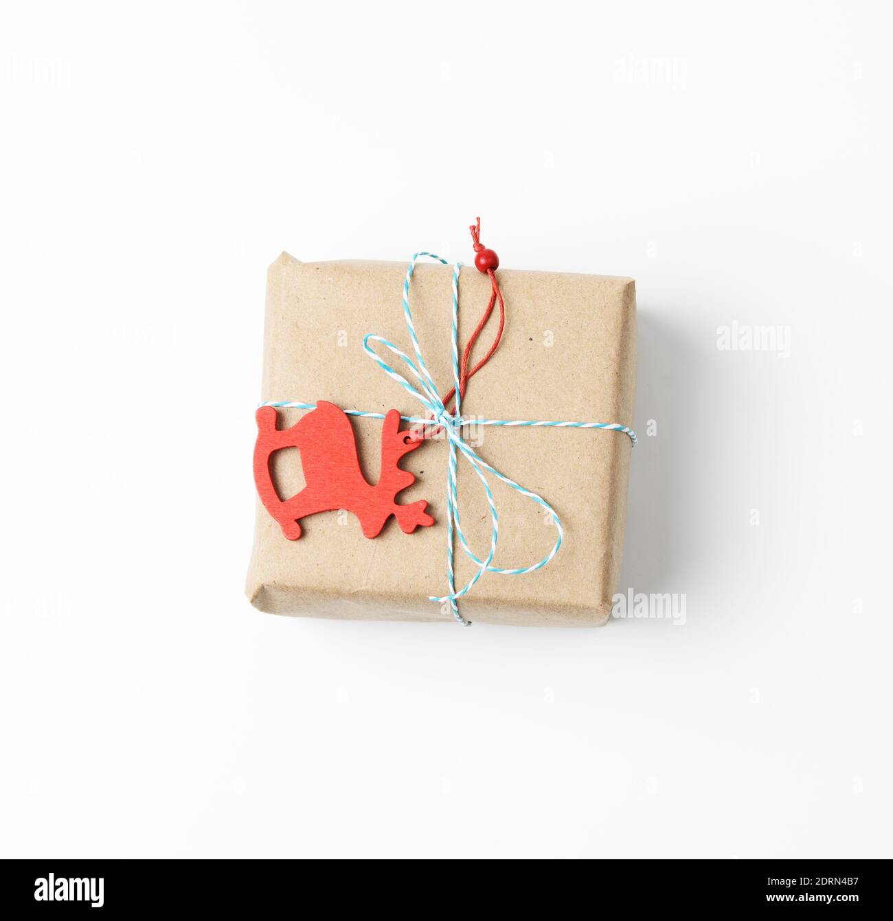 square box wrapped in brown kraft paper and tied with red rope, gift on ...