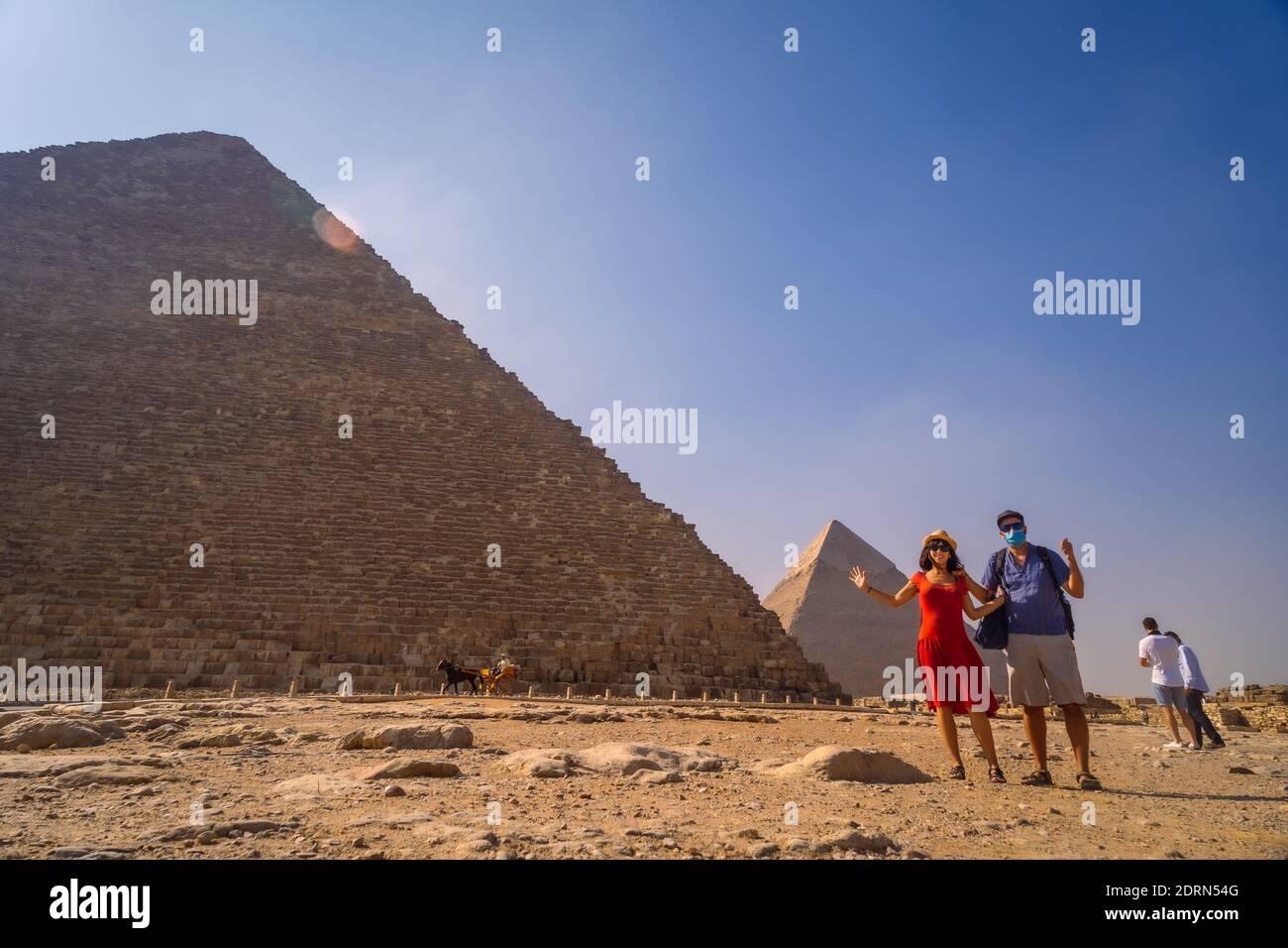 A Caucasian tourist couple posing in front of the great pyramids of ...