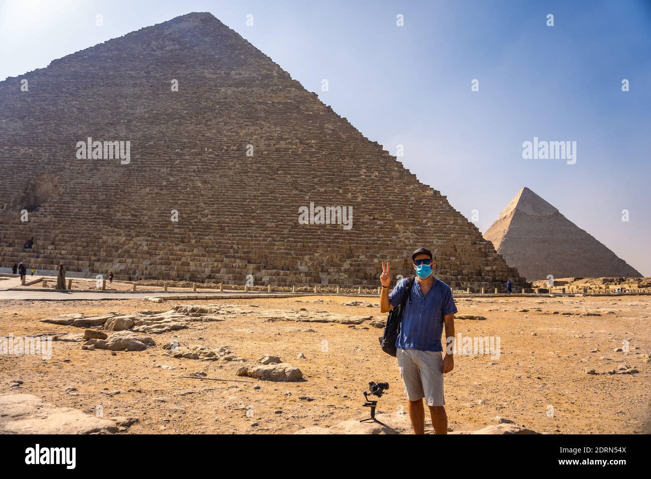 A male Caucasian tourist posing in front of the great pyramids of Giza ...