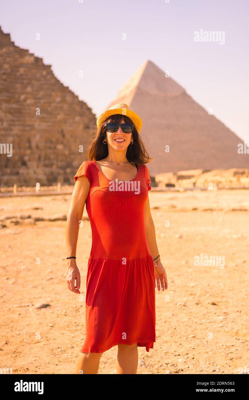 A pregnant Caucasian tourist in red dress posing in front of the great ...