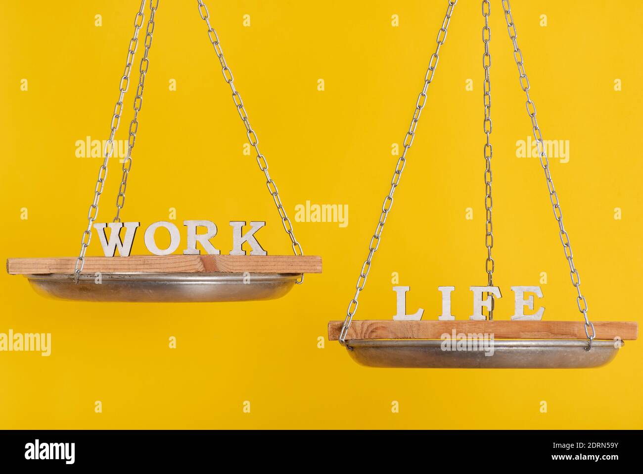 Work vs life. Balance concept. Scales on yellow background close up ...