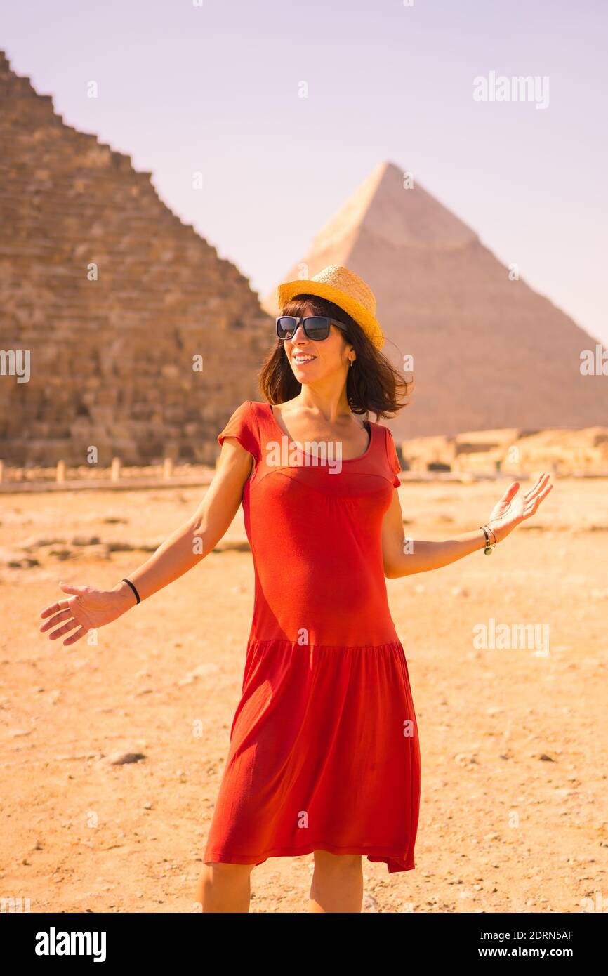 A pregnant Caucasian tourist in red dress posing in front of the great ...