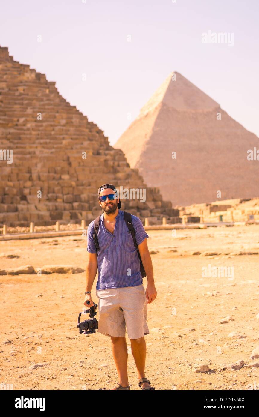 A male Caucasian photographer posing in front of the great pyramids of ...