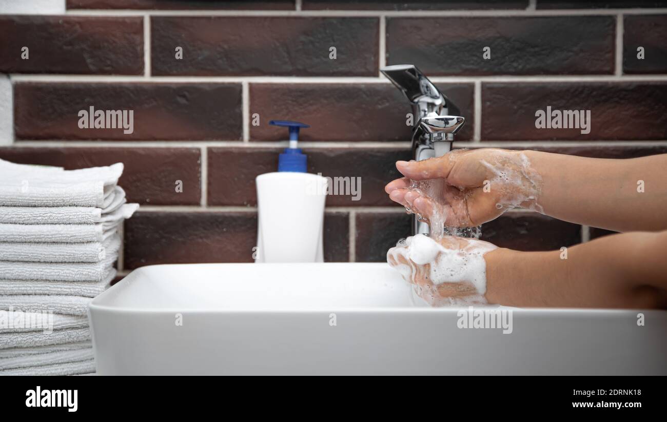 Washing hands with running water in the bathroom. The concept of ...