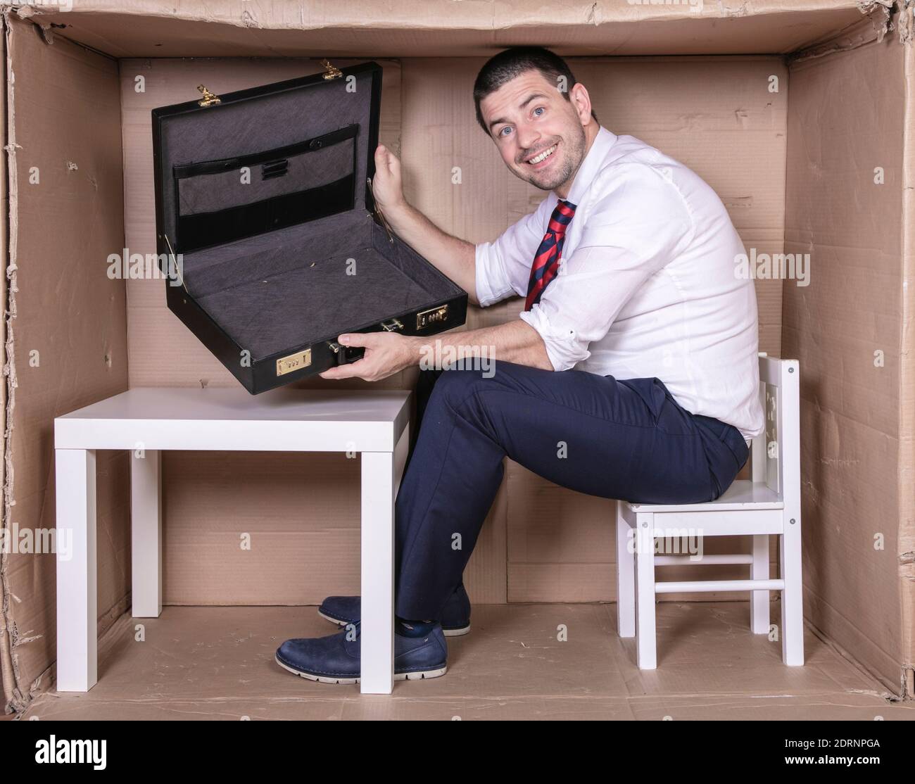 smiling businessman shows empty briefcase, laughs at his own naivety ...