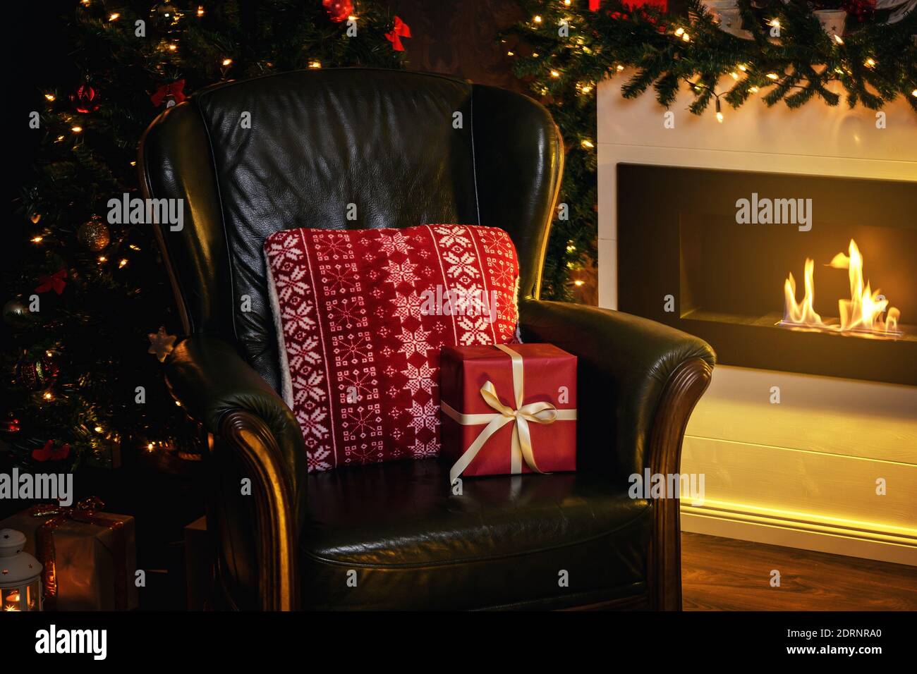 Christmas gifts and armchair beside the fireplace Stock Photo - Alamy