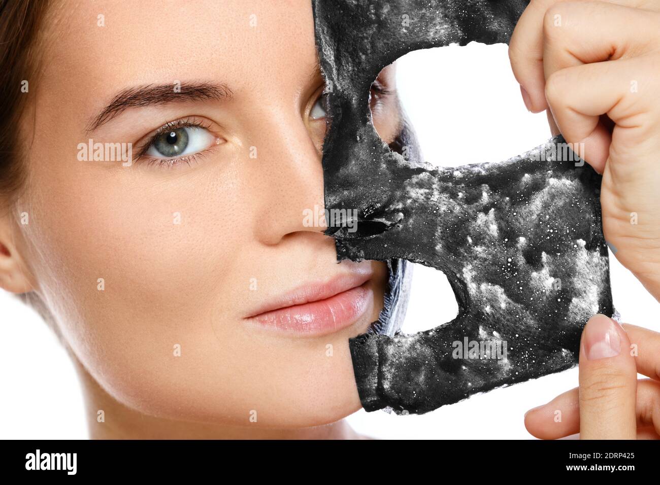 Beautiful woman is removing purifying mask from her face over white ...