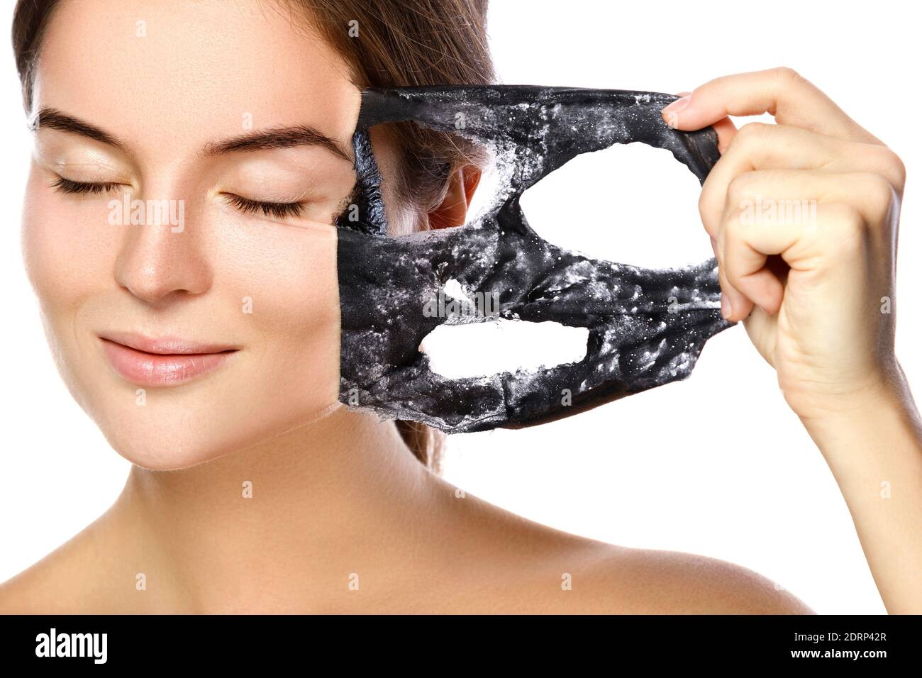 Beautiful woman is removing purifying mask from her face over white ...