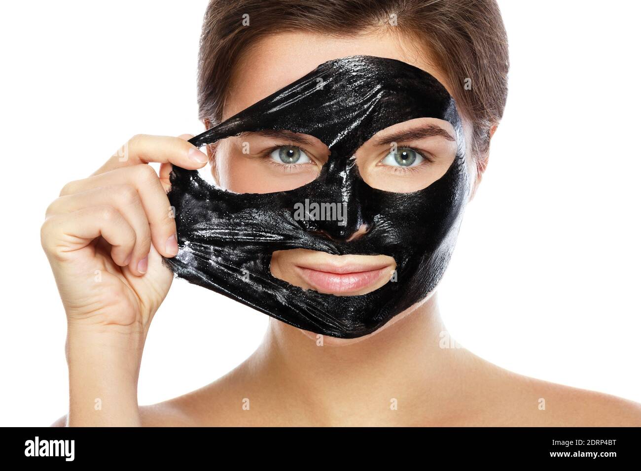 Beautiful woman is removing purifying mask from her face over white ...