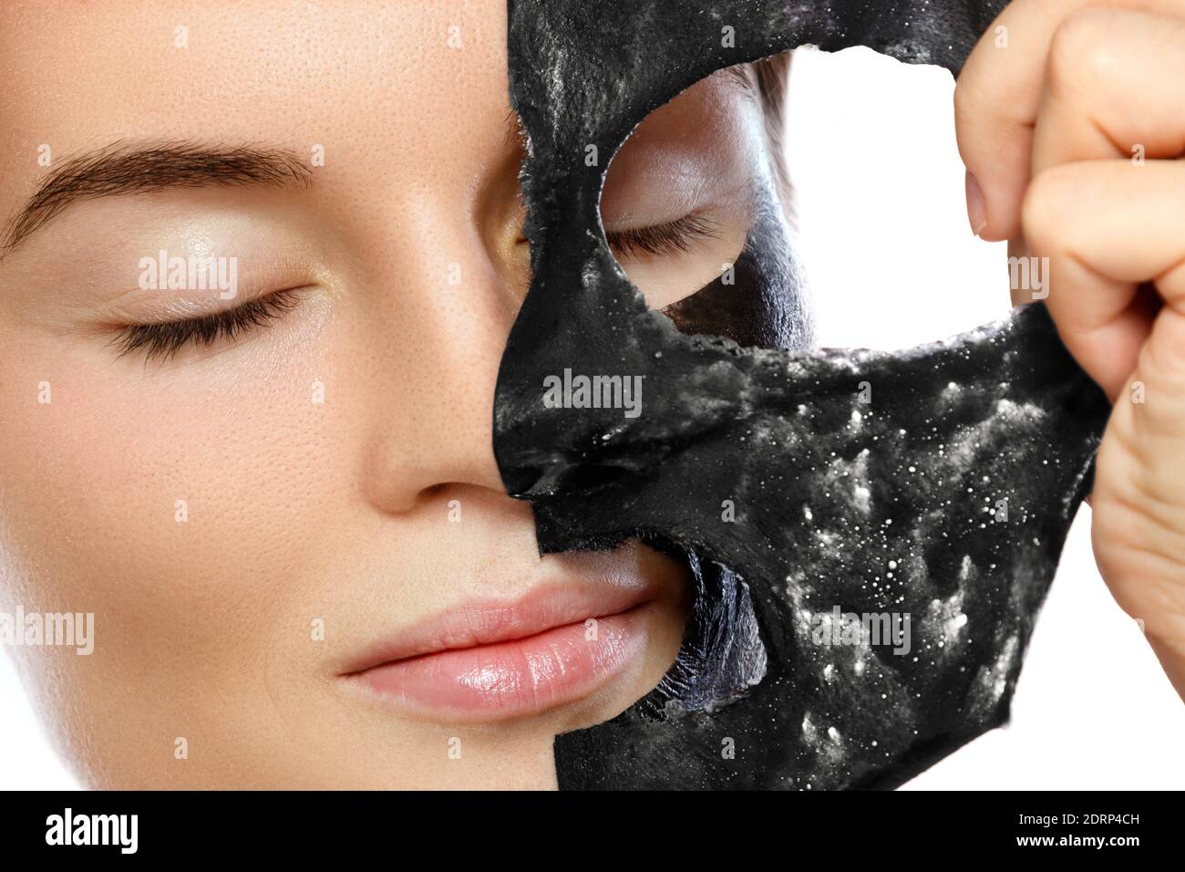 Beautiful woman is removing purifying mask from her face over white ...