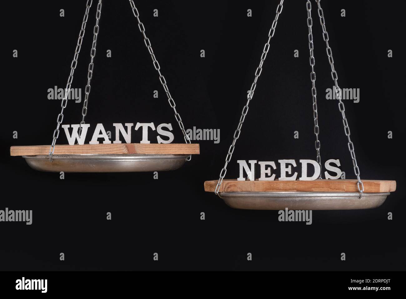 Balance what you want and what you need. Scales on black background ...