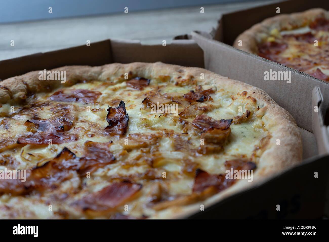 Closeup view of two pizzas on cardboard boxes.Carbonara pizza with ...