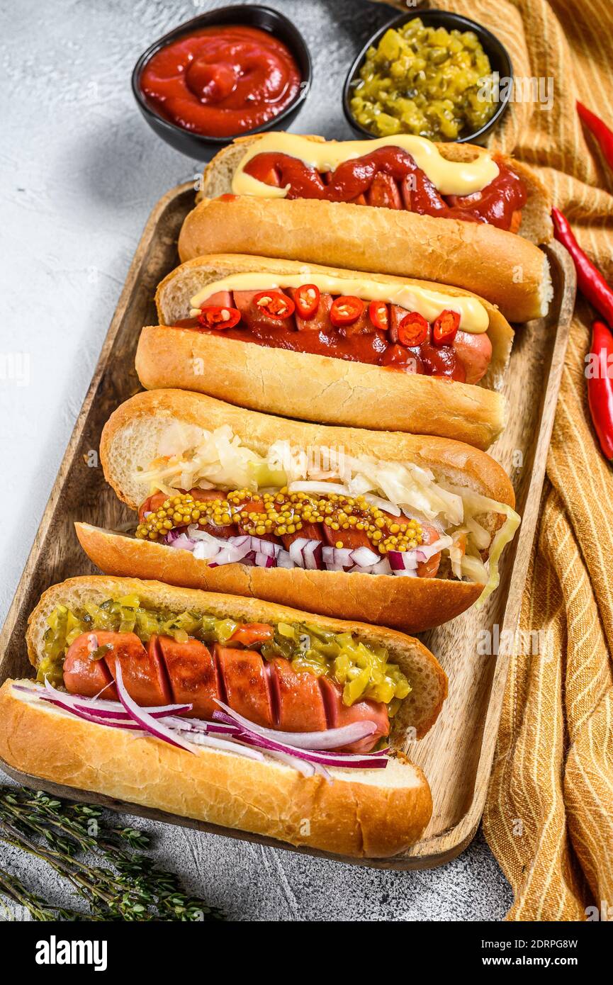 Hot dogs fully loaded with assorted toppings on a tray. Delicious hot ...