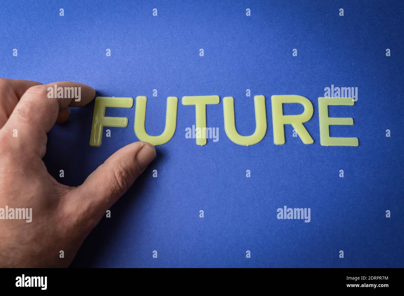 Human fingers holding the word Future written with plastic letters on ...