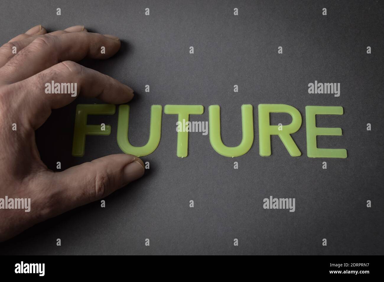 Human fingers holding the word Future written with plastic letters on ...