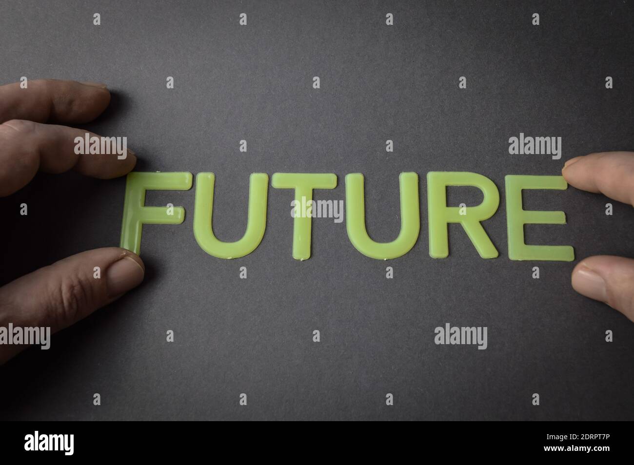 Human fingers holding the word Future written with plastic letters on ...