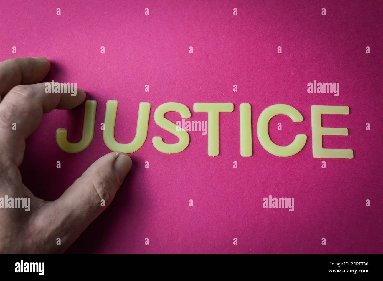 Human fingers holding the word Justice written with plastic letters on ...
