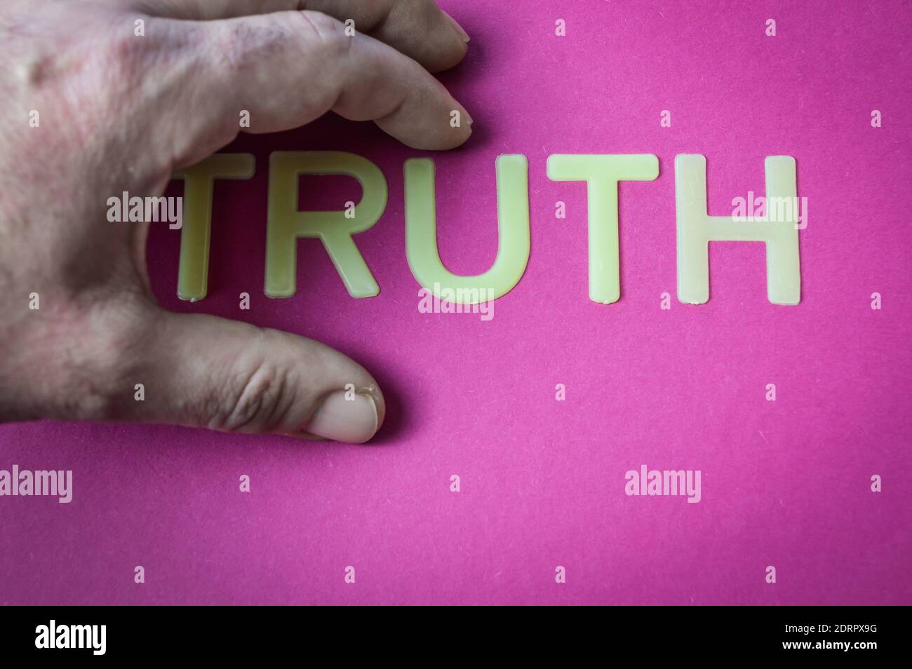 Human hand hiding the word Truth written with plastic letters on a ...