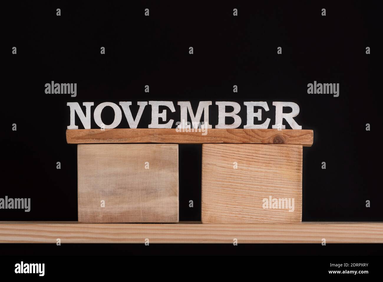 Word November by wooden letters on black background. Front view. Autumn ...
