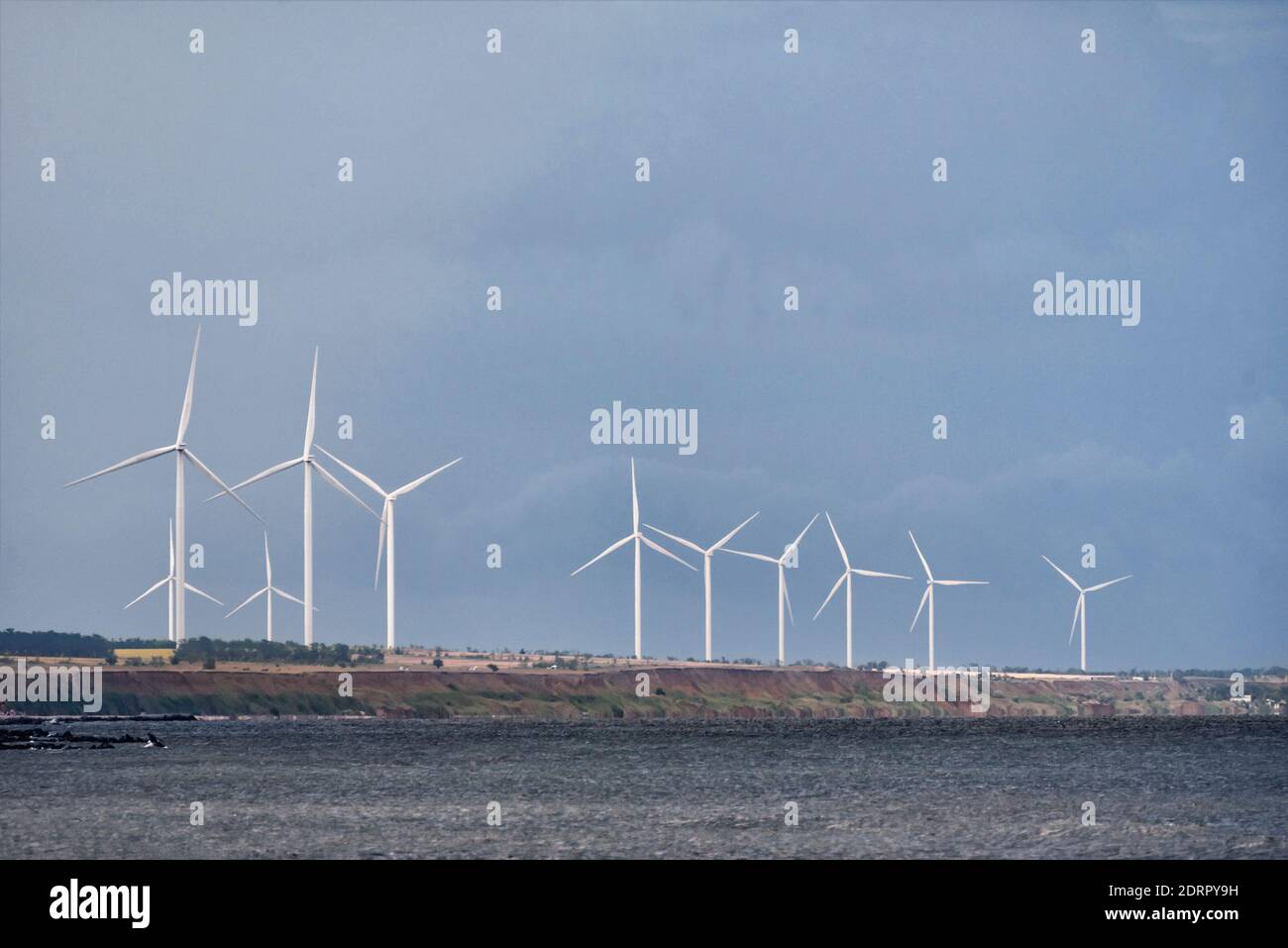 Wind wheels in the sea on blue sky background. Wind energy Stock Photo ...