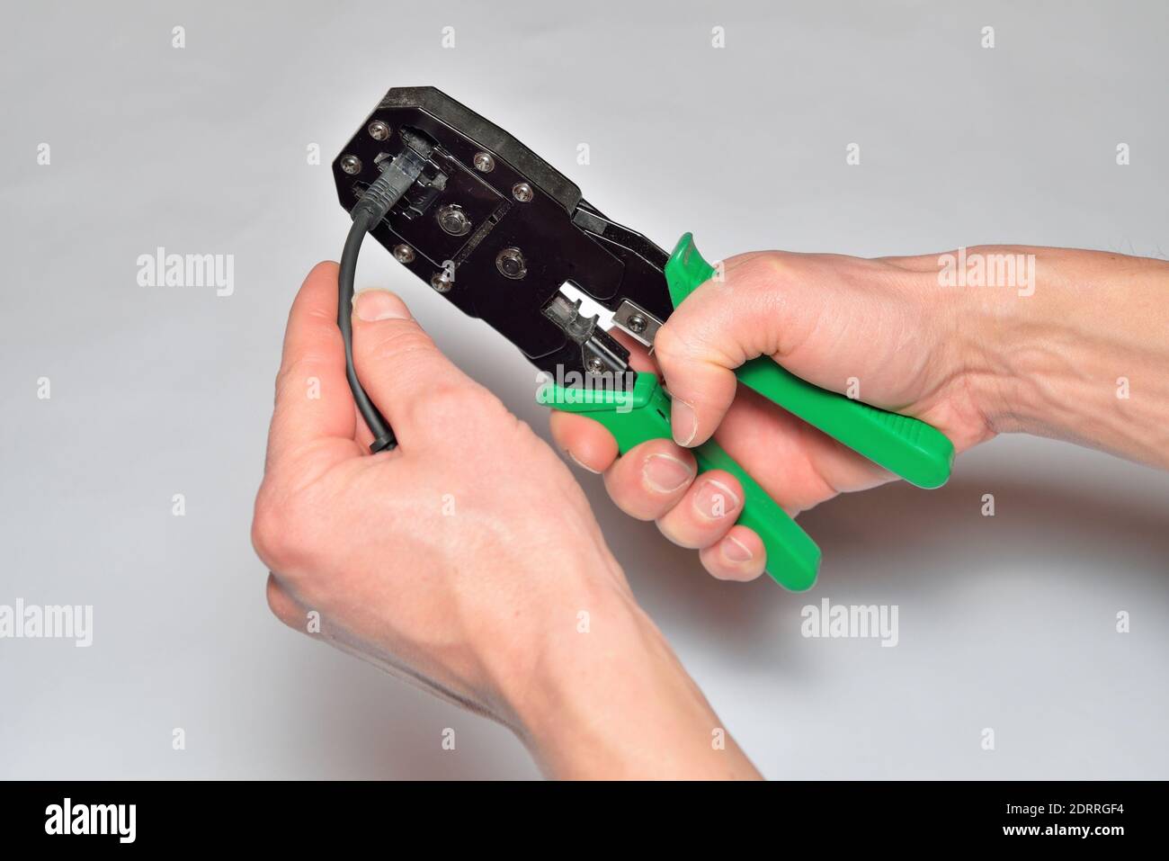 Hands of the installer of computer networks crimped connector on the ...