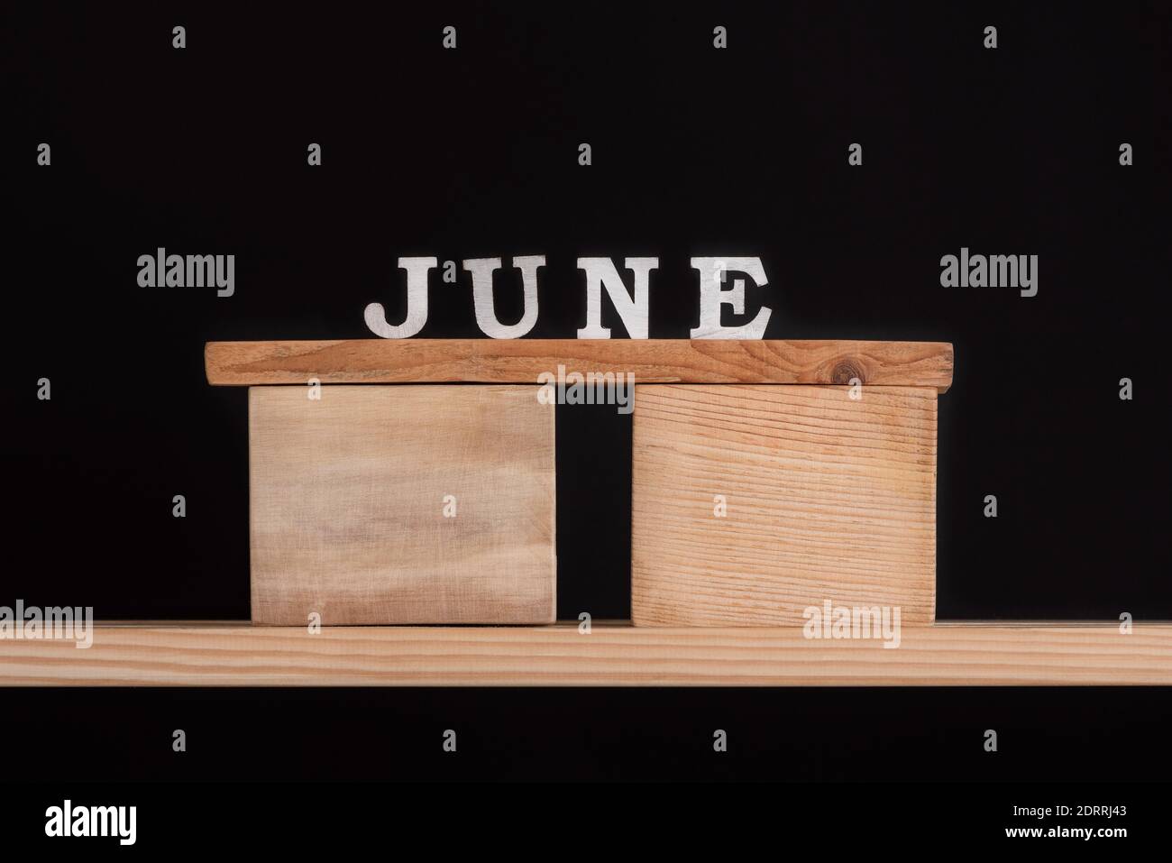 Word June by wooden letters on black background. Month name. Summer ...