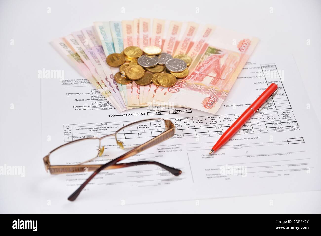 Workplace of accountant: invoice, paper money, coins, glasses and pen ...
