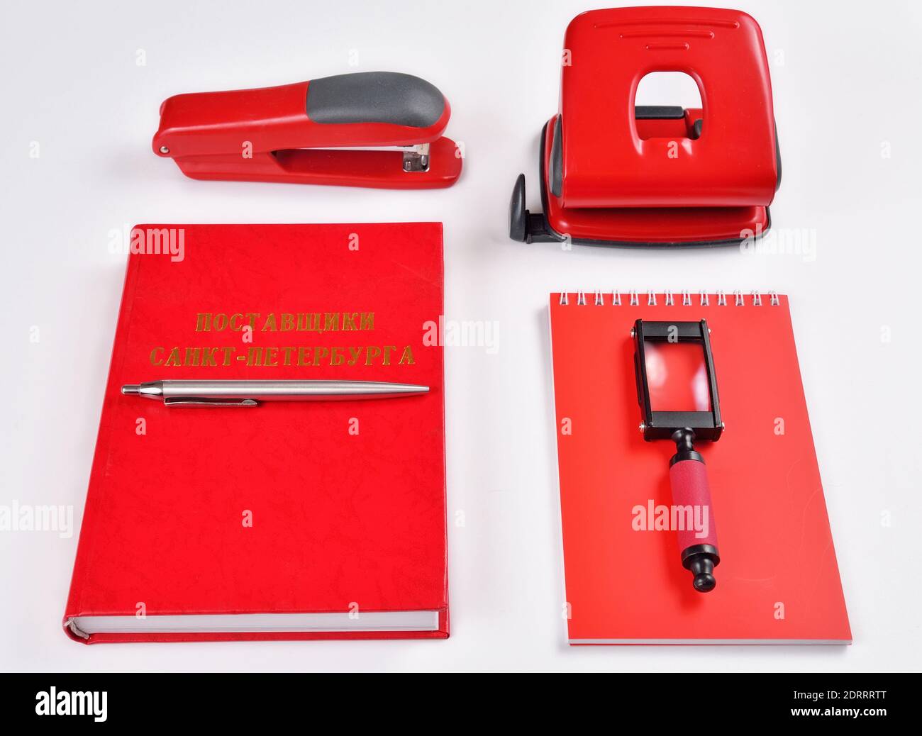 Red office supplies: stapler, hole punch, Notepad, magnifier, book and ...