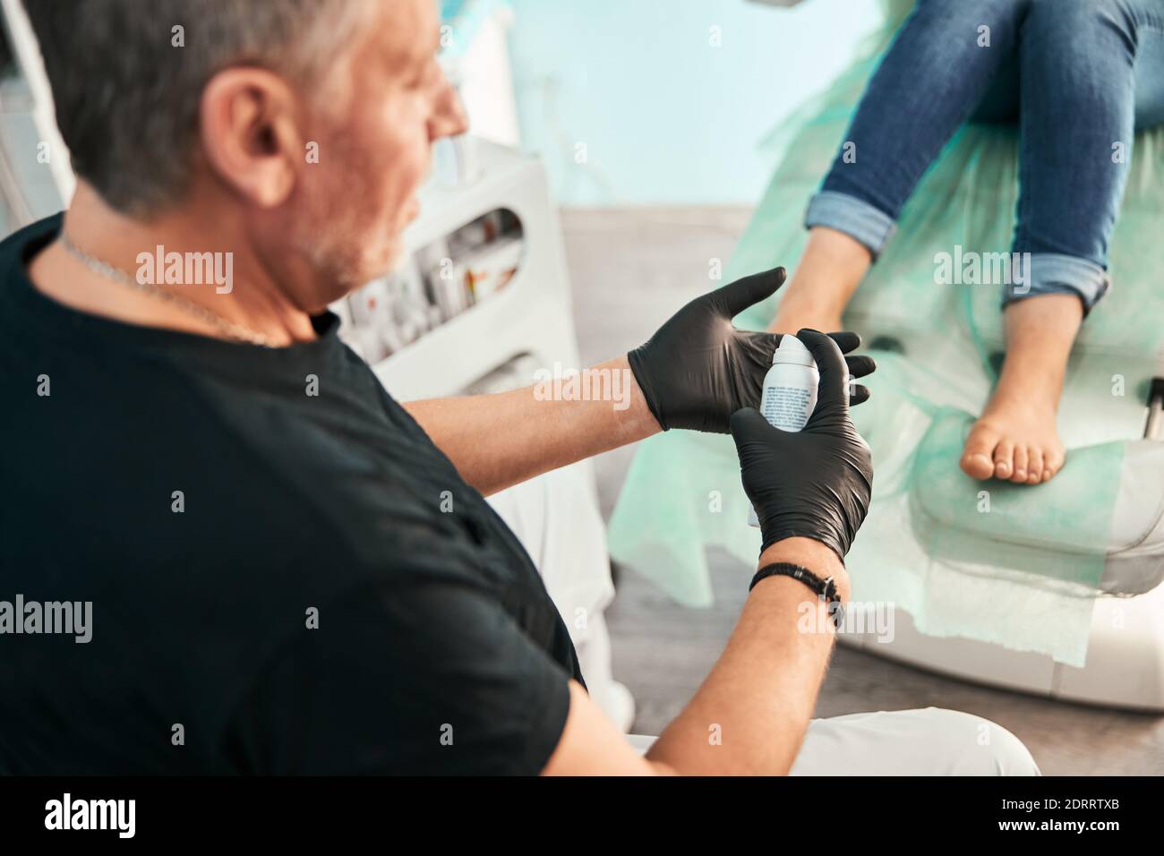 Competent medical worker putting cream on hand Stock Photo - Alamy