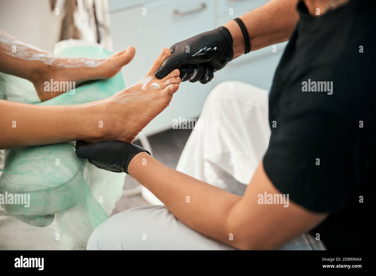 Competent podologist doing foot massage for patient Stock Photo - Alamy