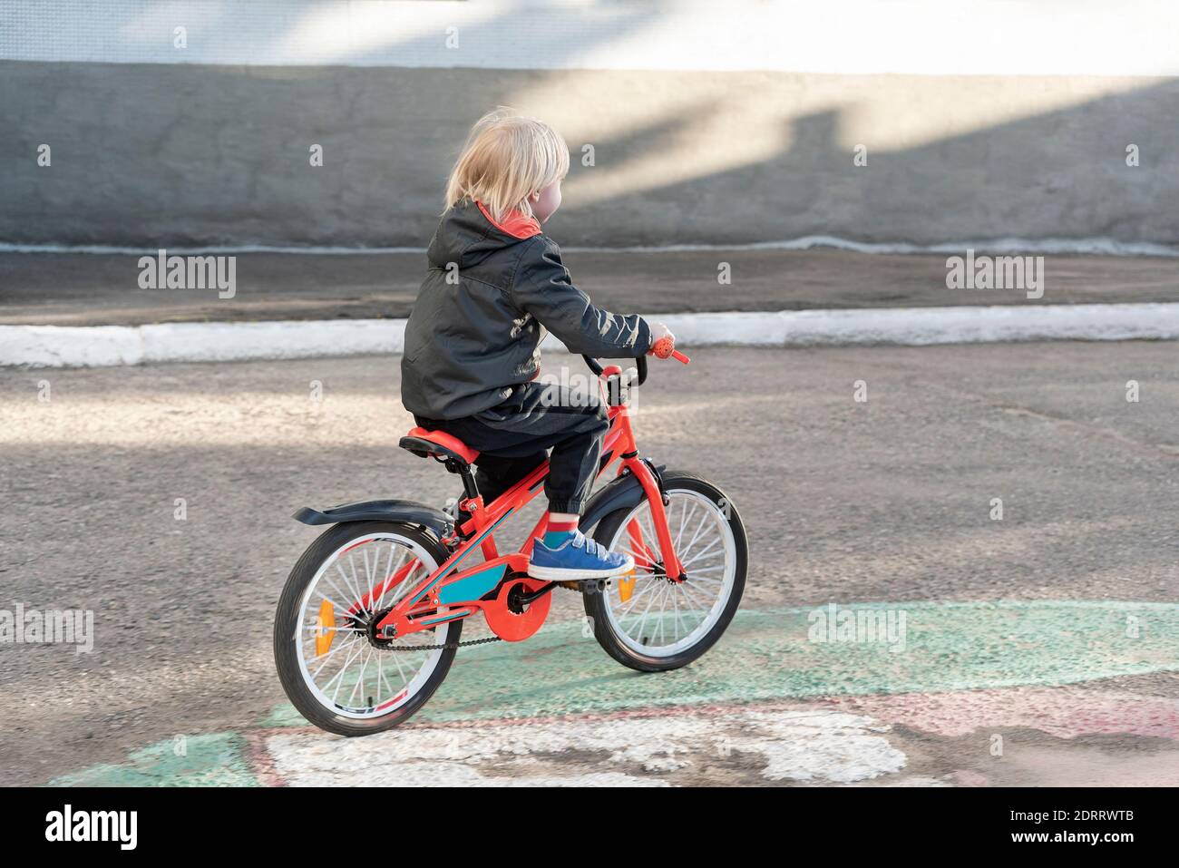 Rear view of boy riding a bicycle. Child learns to ride bike Stock ...