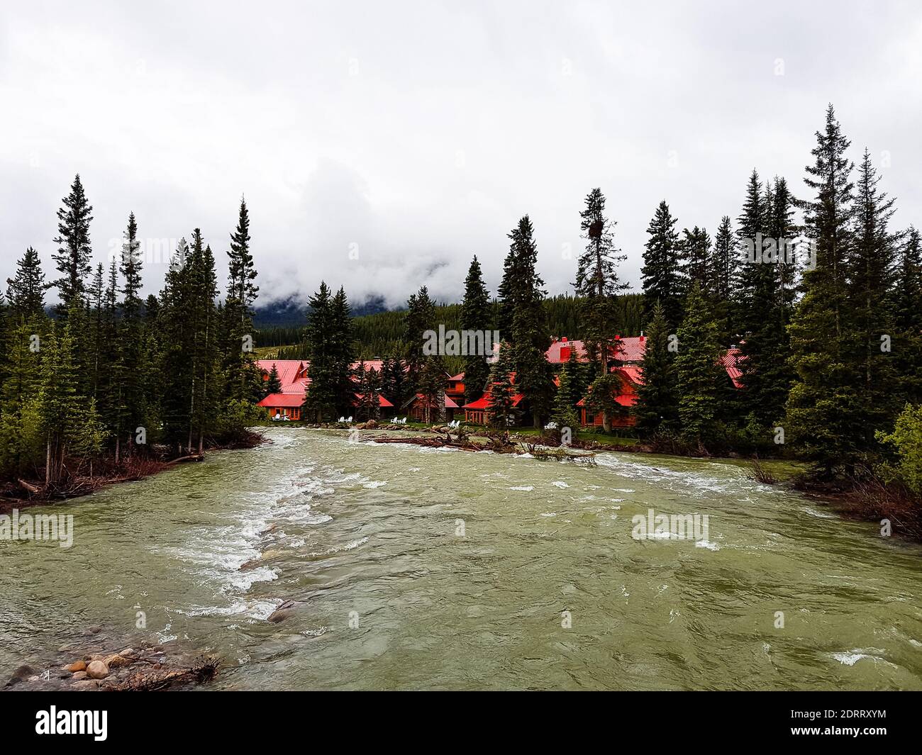 Large building with red roof by the river. Nobody Stock Photo - Alamy