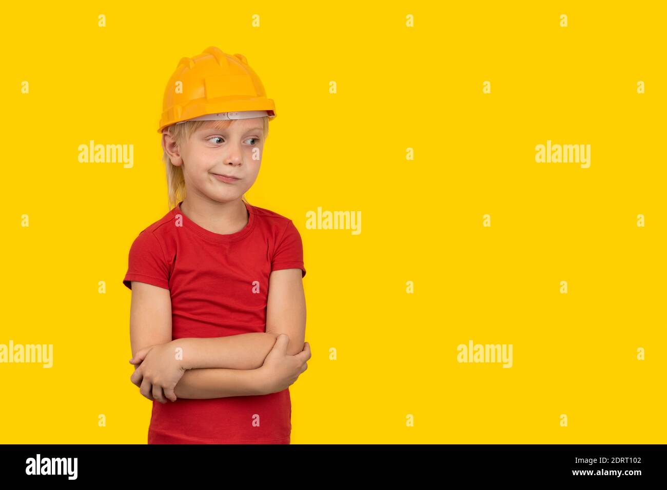 Brooding little boy in an orange helmet on yellow background. Choice of ...