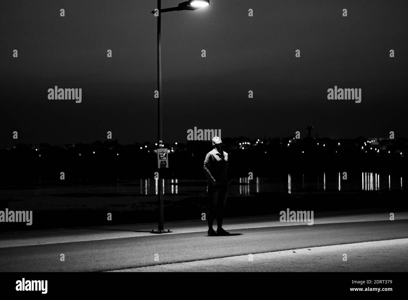 Man standing under street light Black and White Stock Photos & Images ...