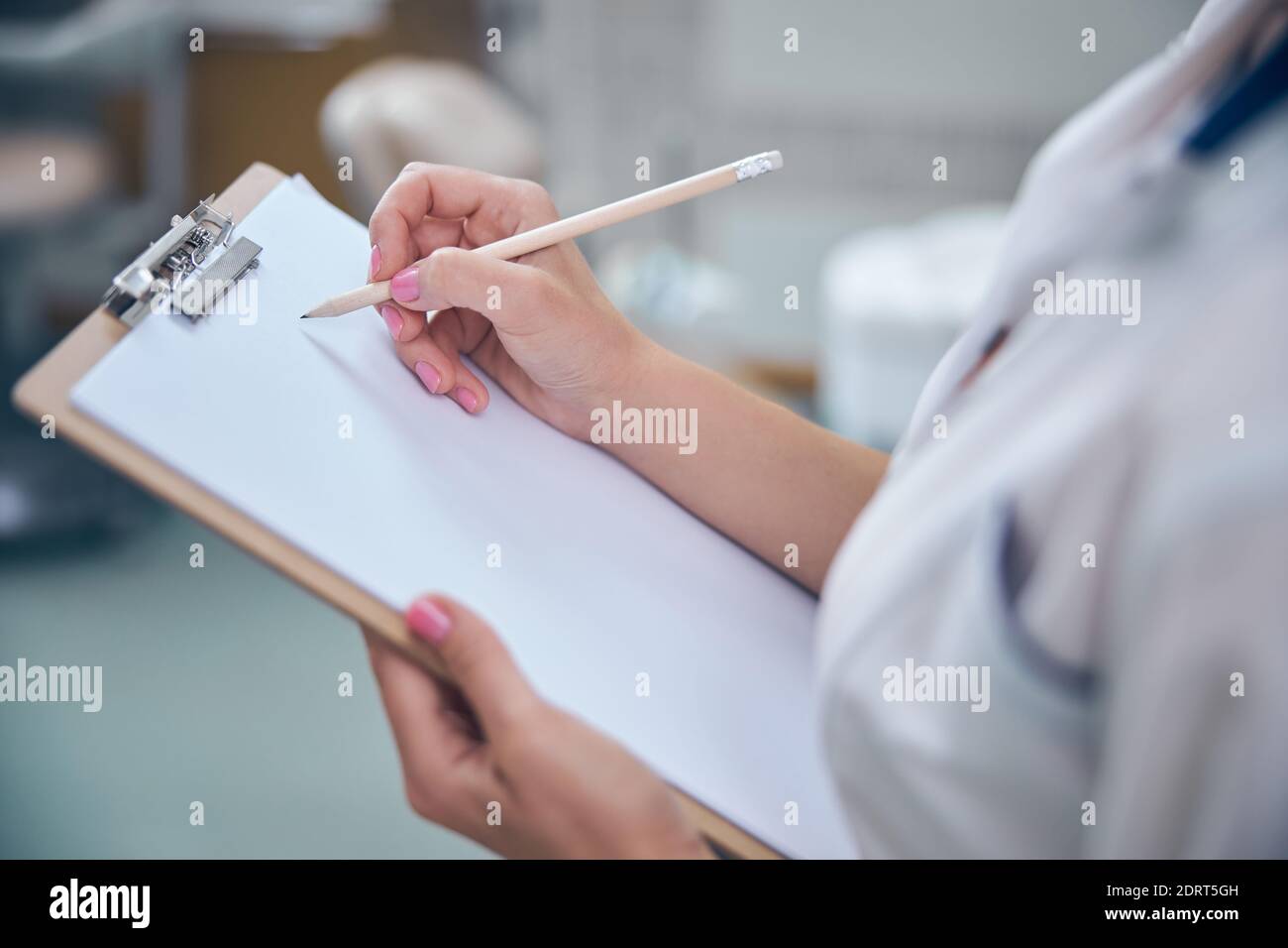 Female doctor making notes about patient health Stock Photo - Alamy