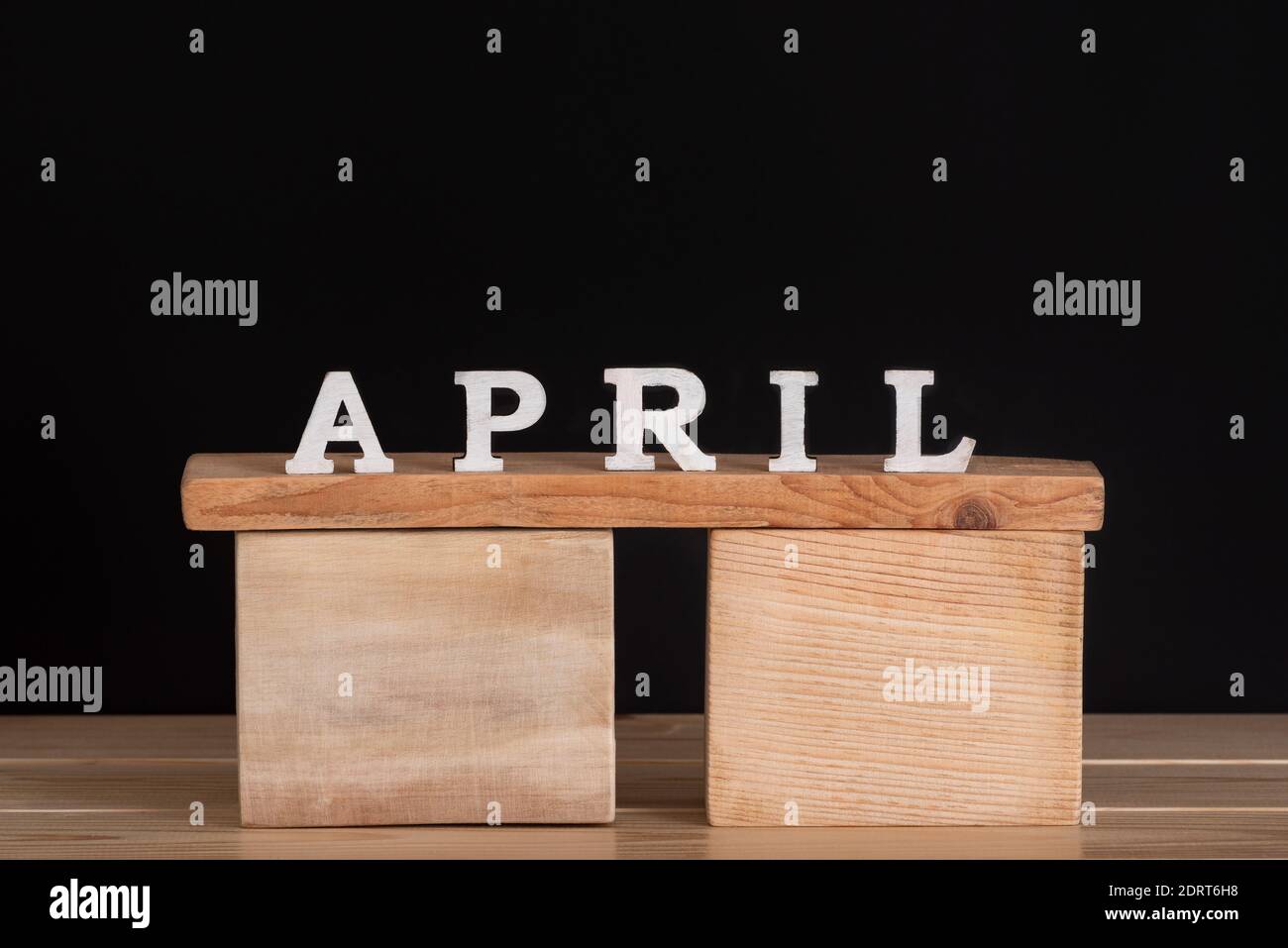 Word April written on wooden blocks. Black background. Spring calendar ...