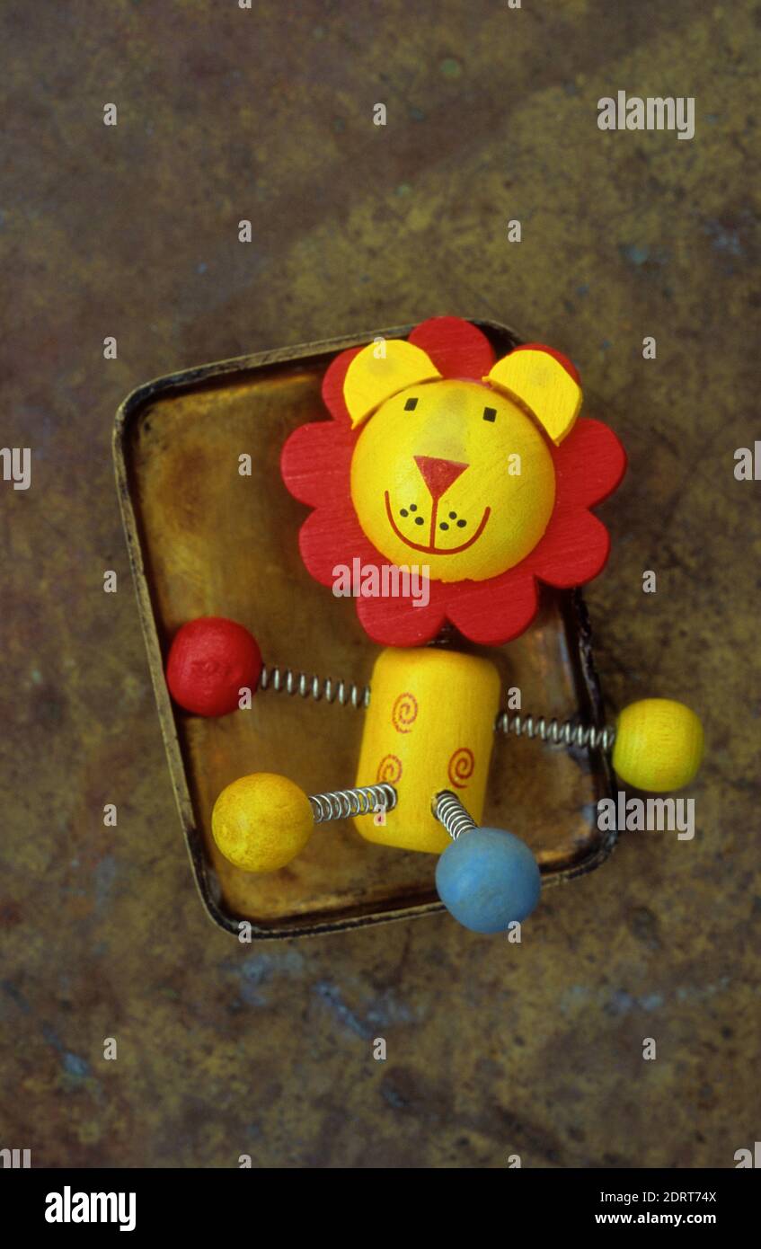 Wooden model of yellow and red lion with springy legs and friendly face ...