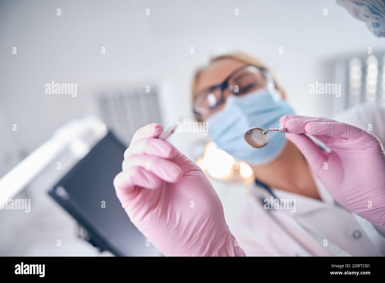 Female dentist using instruments during patient treatment Stock Photo ...