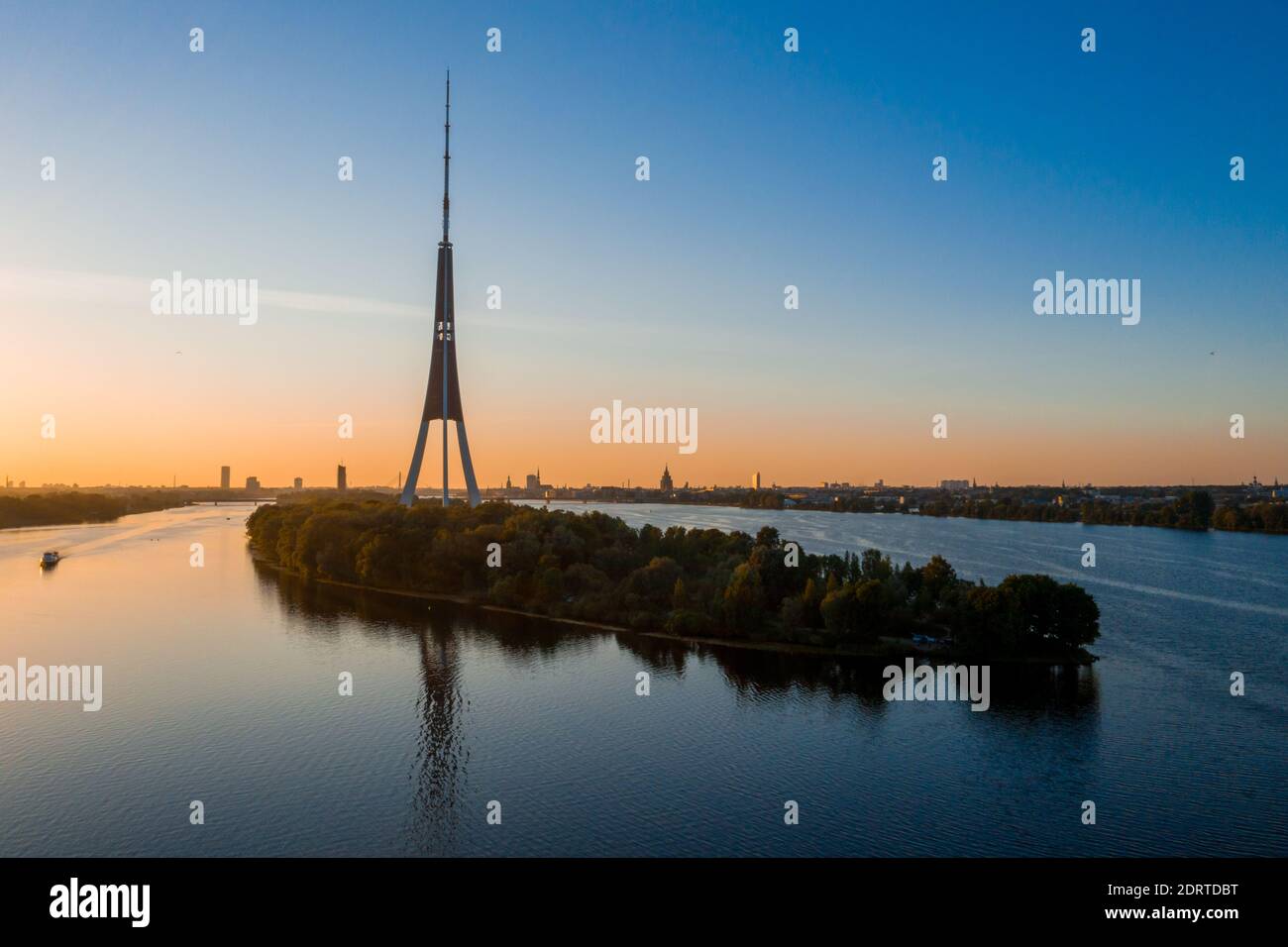 An aerial shot of an island covered with trees and with a tall tower ...